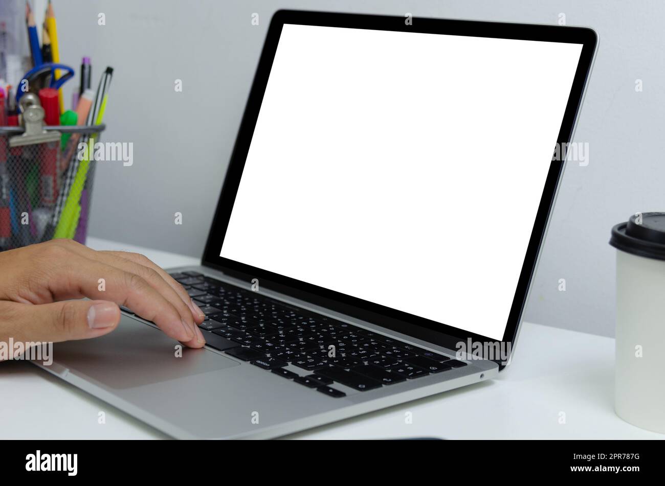 Hand man using keyboard computer laptop mock up blank white screen monitor technology online ...