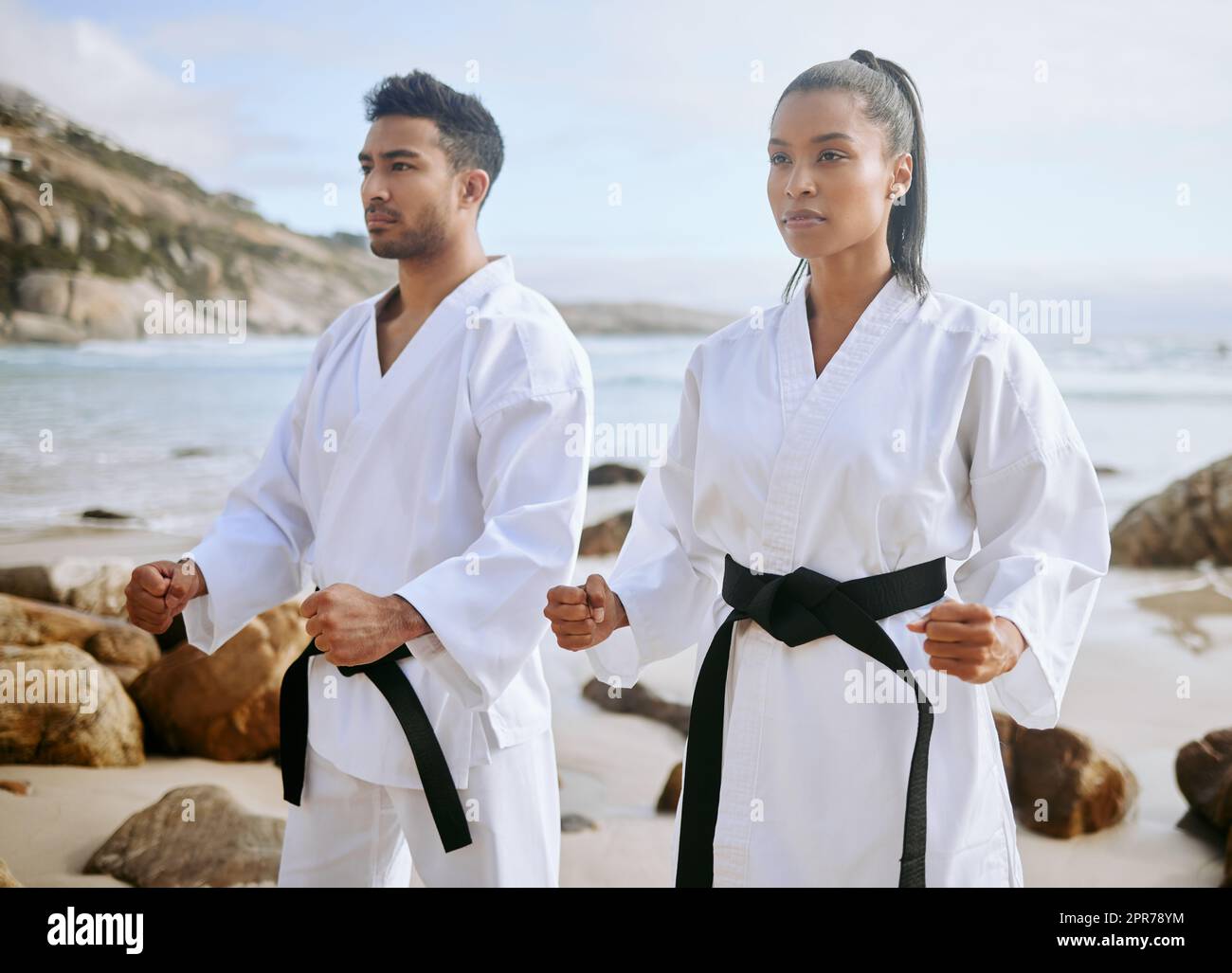 Ready for action. Shot of two young martial artists practicing karate on the beach Stock Photo ...