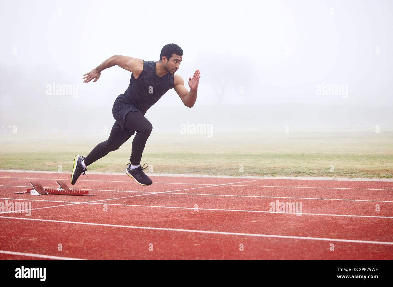 The perfect getaway. Full length shot of a handsome young male athlete running on an outdoor ...