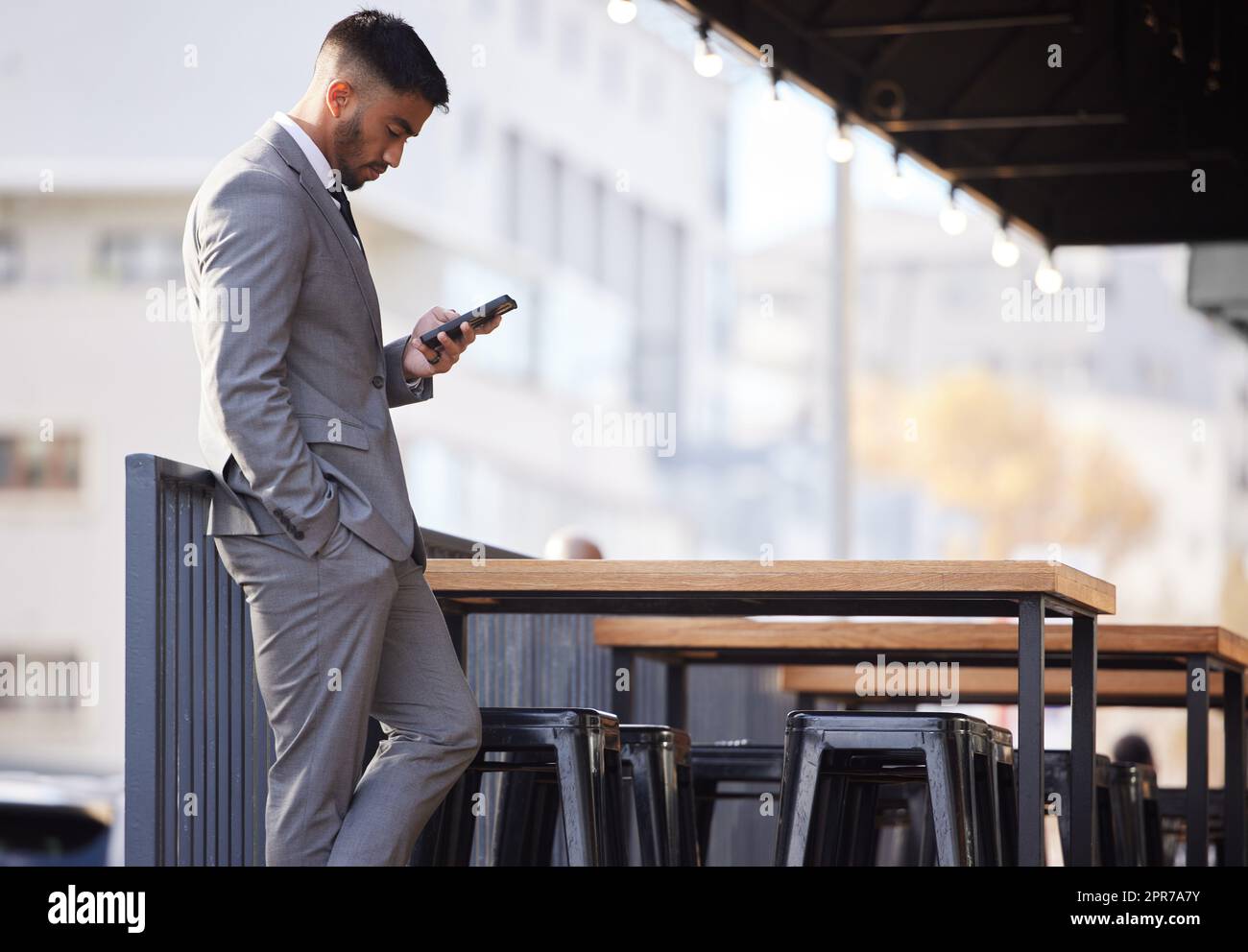 Waiting to be seated. a handsome young businessman checking his ...