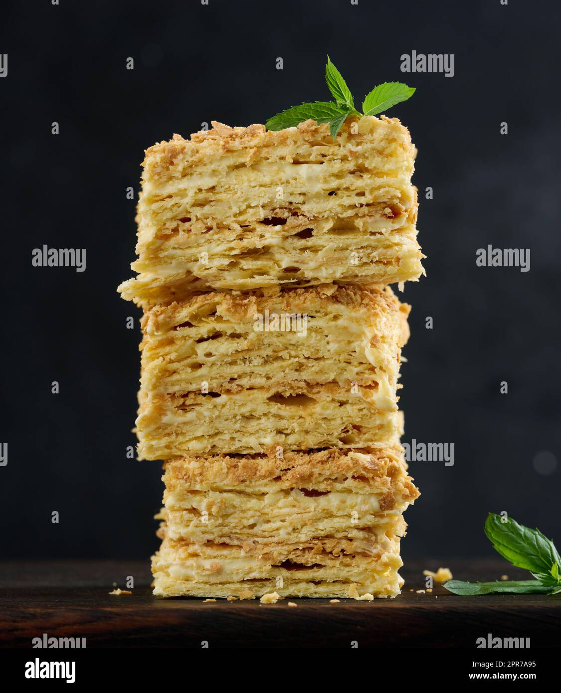 A stack of baked Napoleon pie slices with cream. Puff pastry, delicious ...