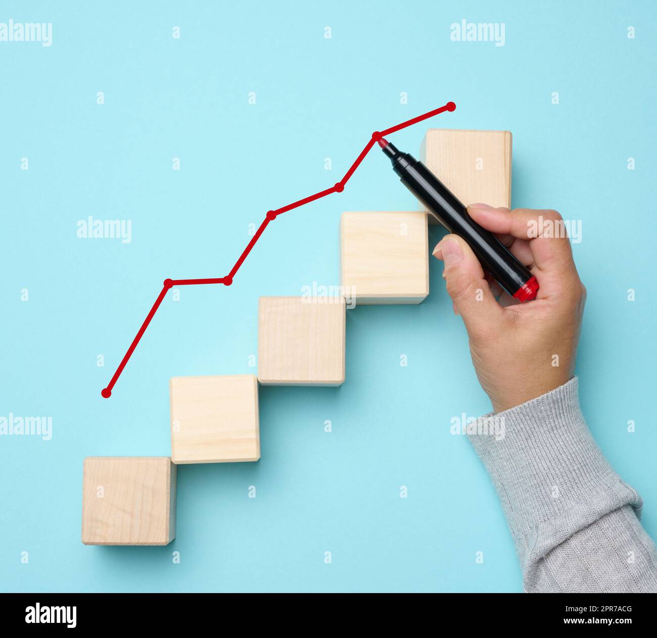 Graph with growing indicators and a female hand with a marker on a blue ...