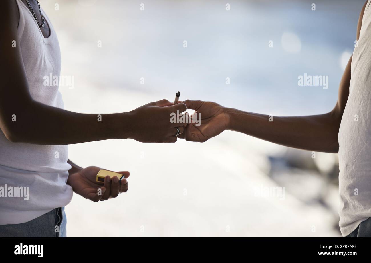Puff, puff, pass. two unrecognisable men smoking a marijuana cigarette ...