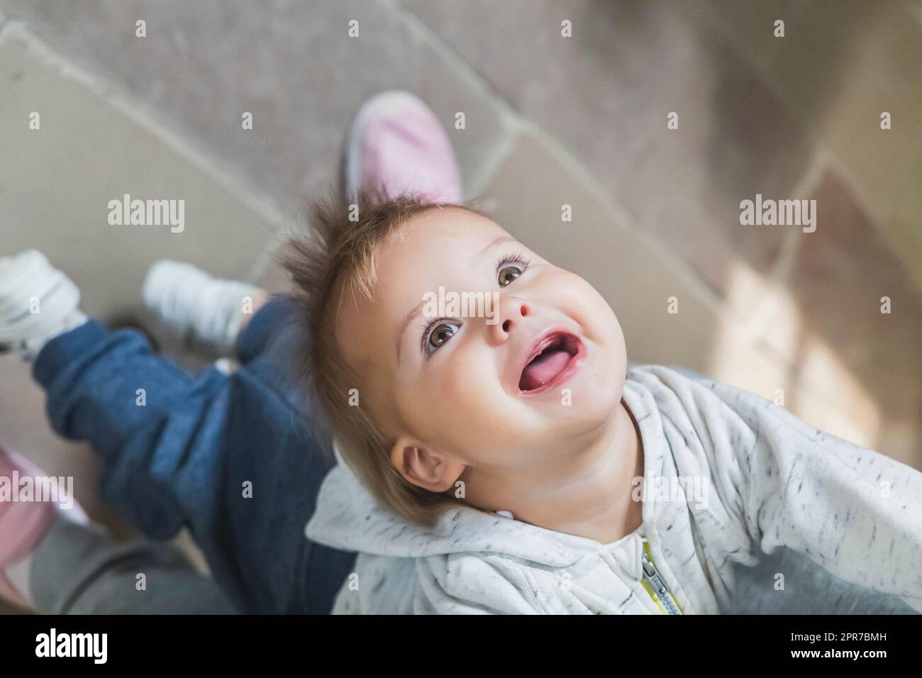 beautiful toothless baby leaned back holding mom's hands Stock Photo ...