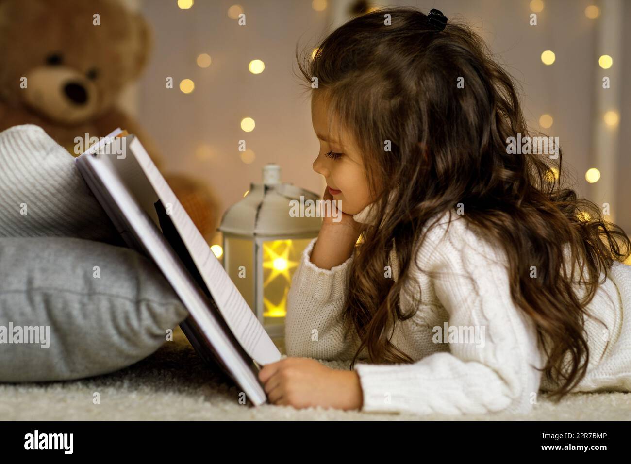 child girl is reading book Stock Photo - Alamy
