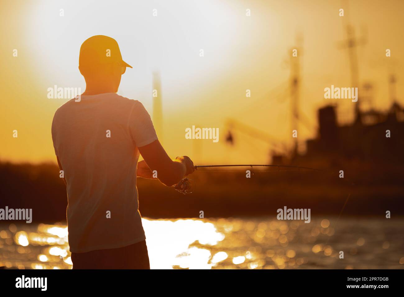 Young man fishing at sea Stock Photo - Alamy