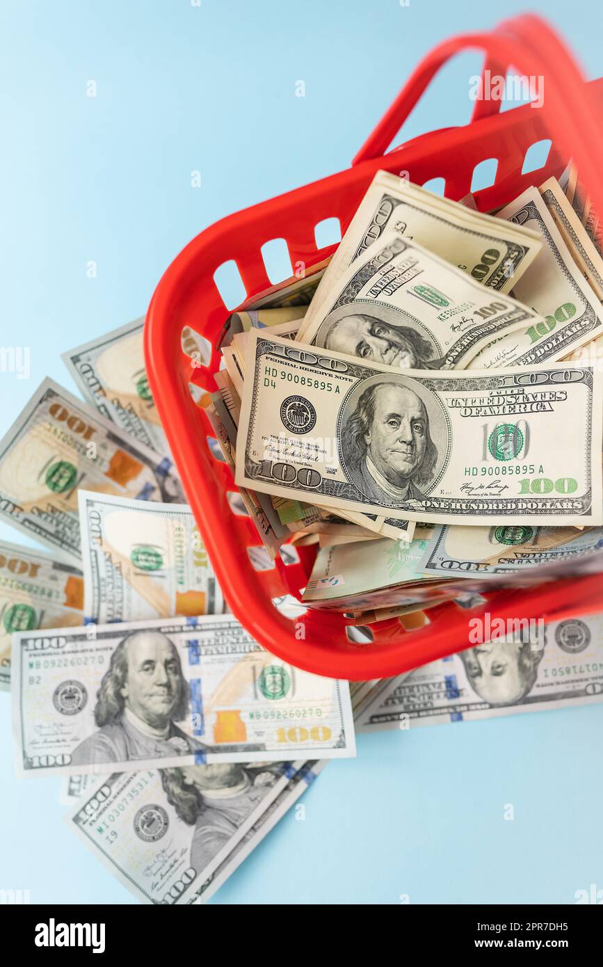 Red grocery cart with many 100 dollar bills inside. The concept of ...