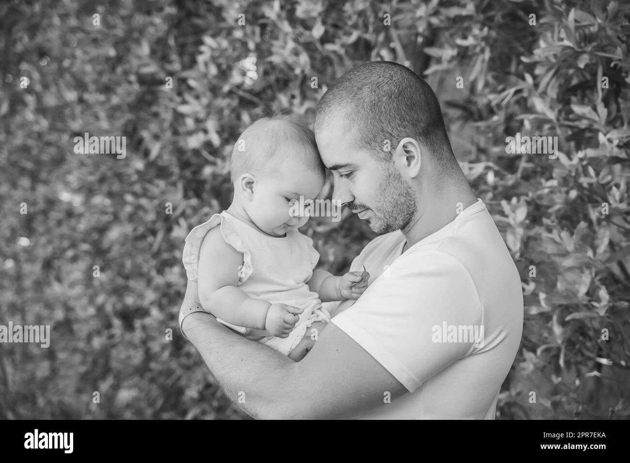 father and daughter leaned their heads to each other in the garden ...
