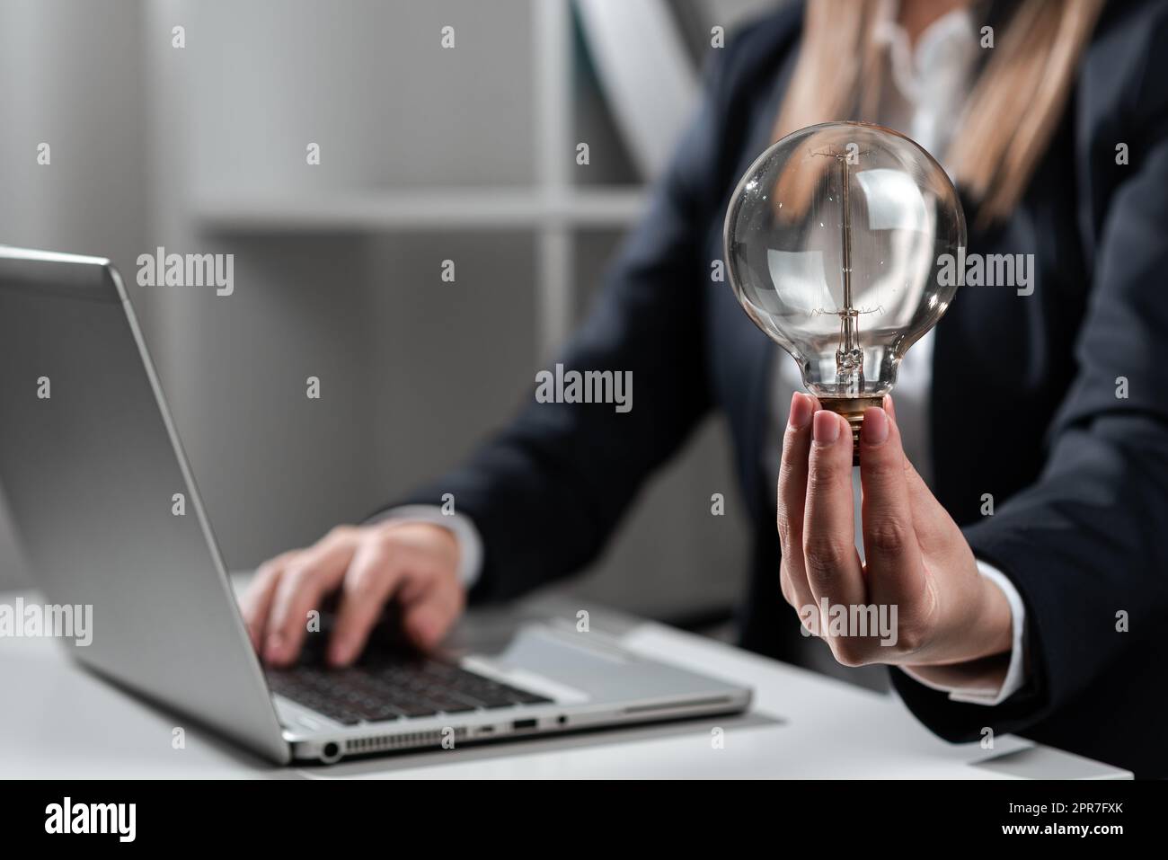 Businesswoman Typing Recent Updates On Lap Top On Desk Holding ...