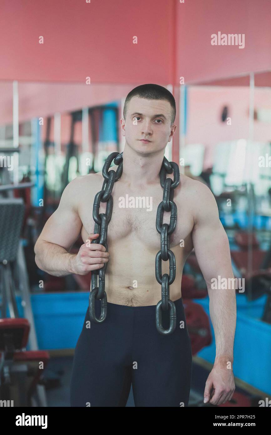 an athlete stands in a gym with a large chain around his neck Stock ...