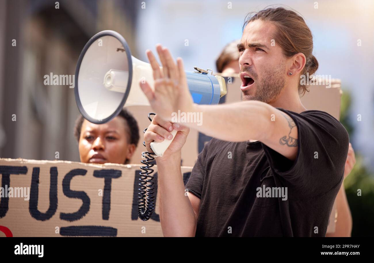 The leader of the movement. a young man with his hand raised speaking ...