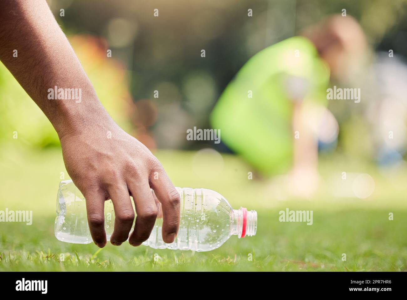 Plastic has no place in nature. an unrecognisable person picking up ...
