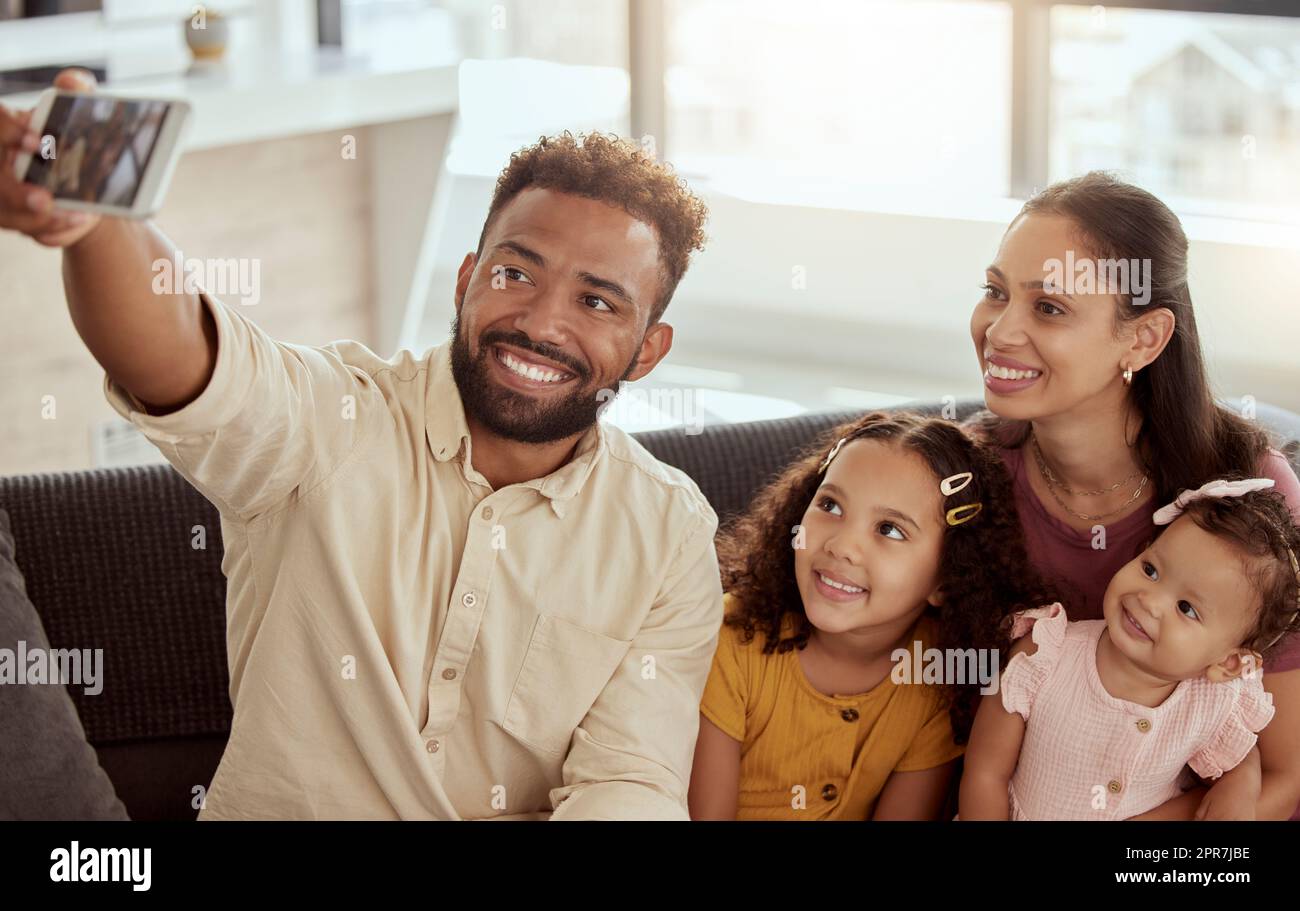 Smiling mixed race parents taking selfie on cellphone with adorable ...