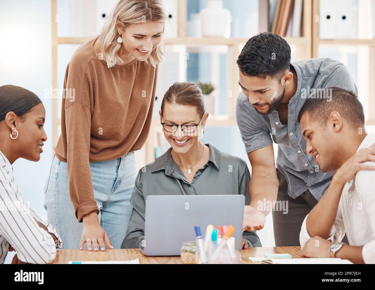 Group of happy diverse colleagues brainstorming together on laptop in ...