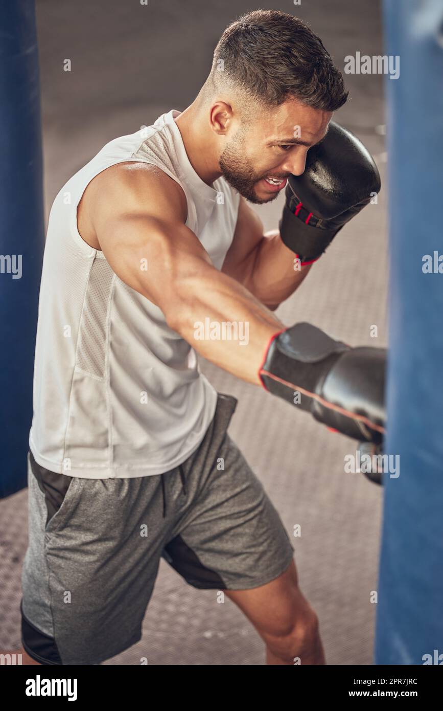 Boxer hitting a punch bag in the gym. Strong mma fighter punching in ...