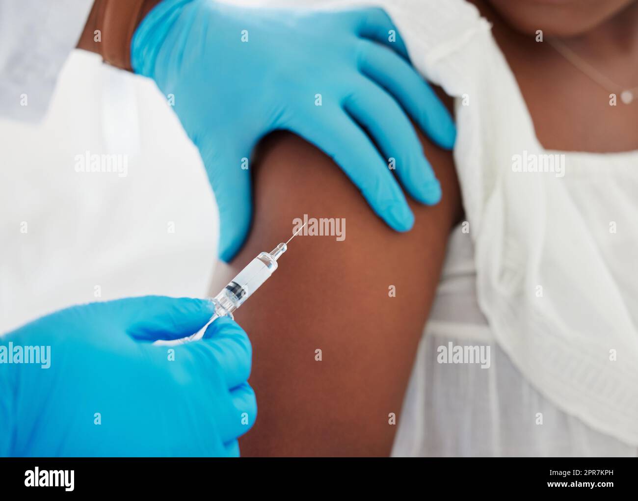Doctor injecting a patient with a needle. This syringe holds the cure ...