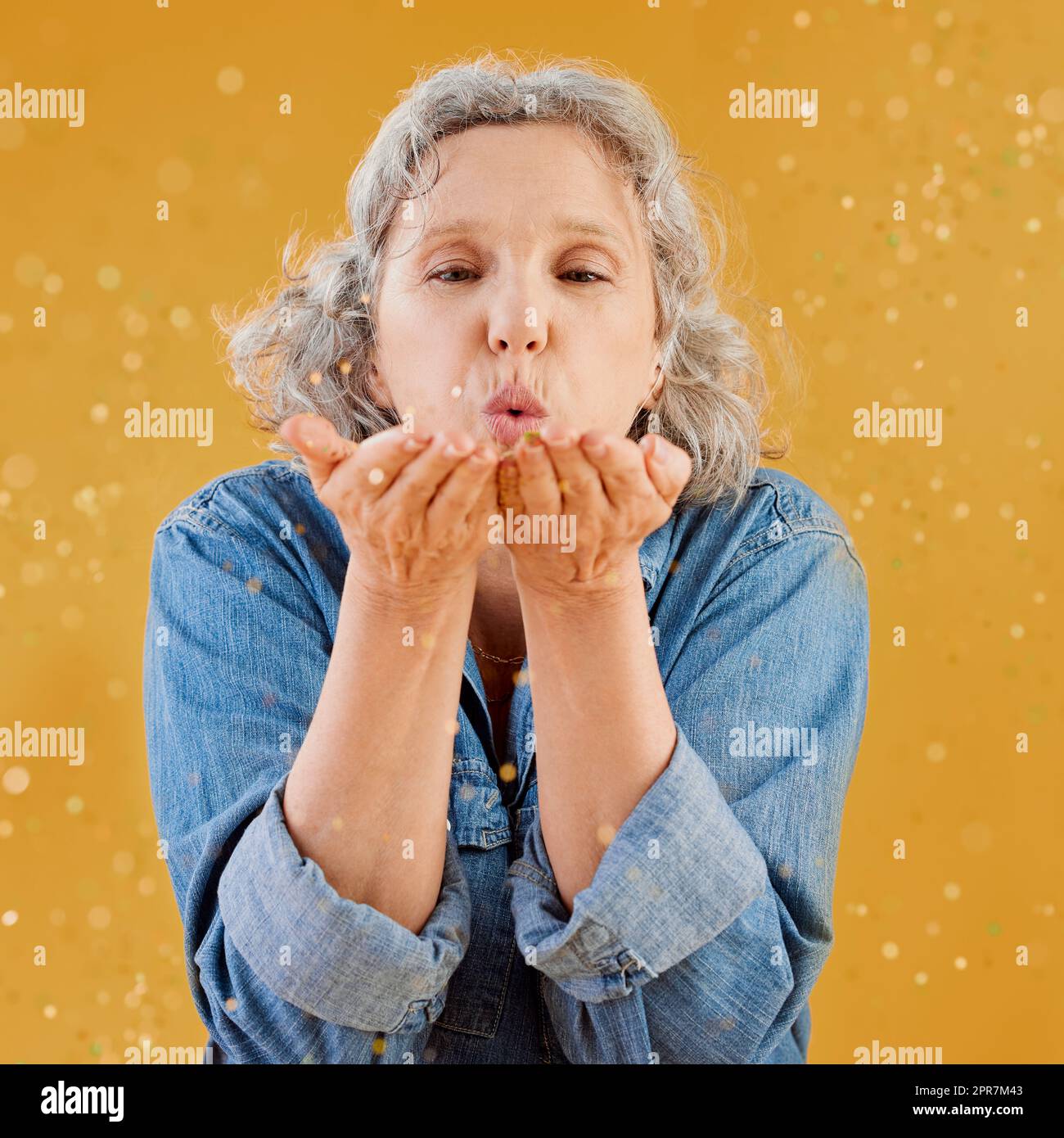 One Happy Mature Caucasian Woman Blowing Confetti Out Of The Palm Of