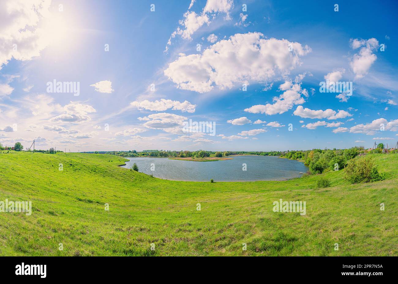 Green field and blue pond in the village Vchorayshe, Zhytomyr Region ...