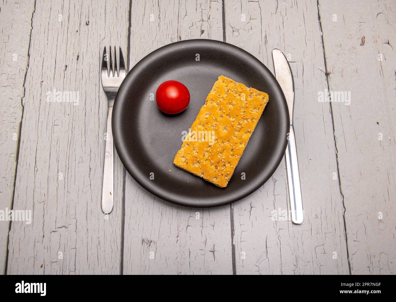 plate with cutlery, tomato and slice of bread Stock Photo - Alamy