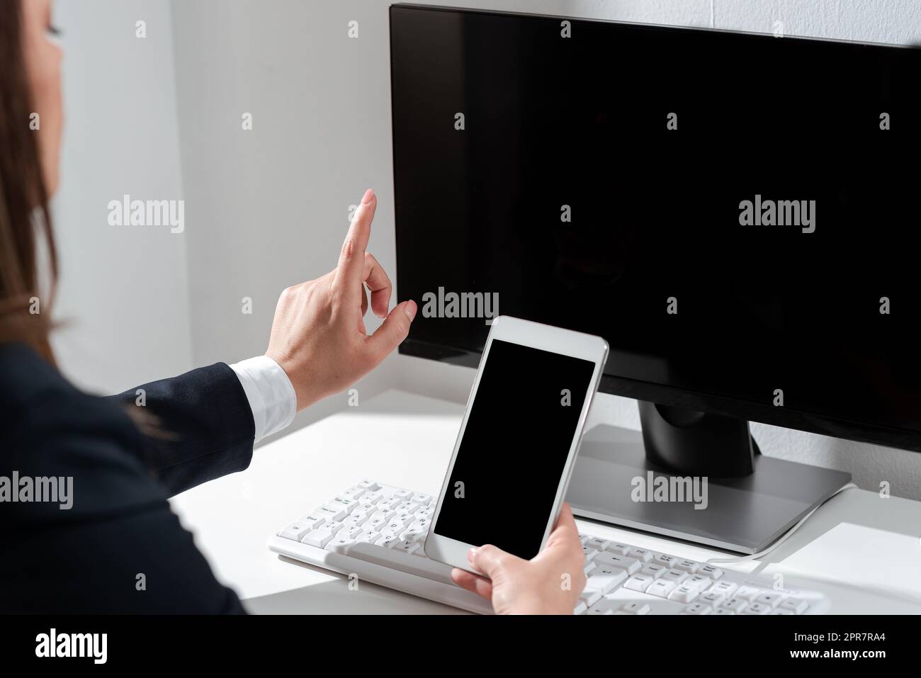 Businesswoman Holding Mobile Phone And Pointing With One Finger On ...