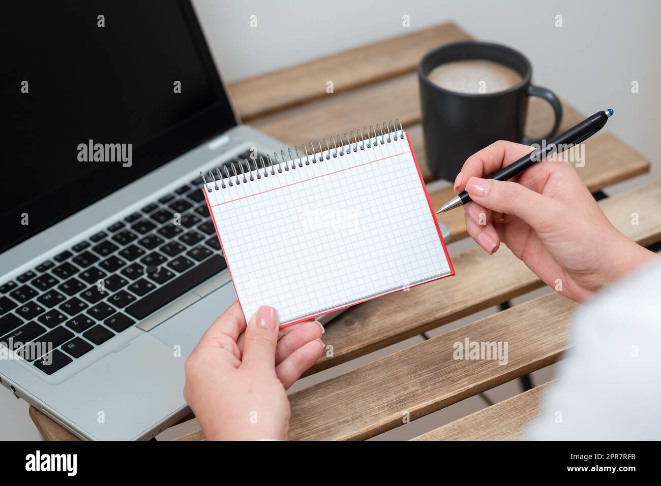 Businesswoman Holding Pen And Notepad With Important Message On Table ...