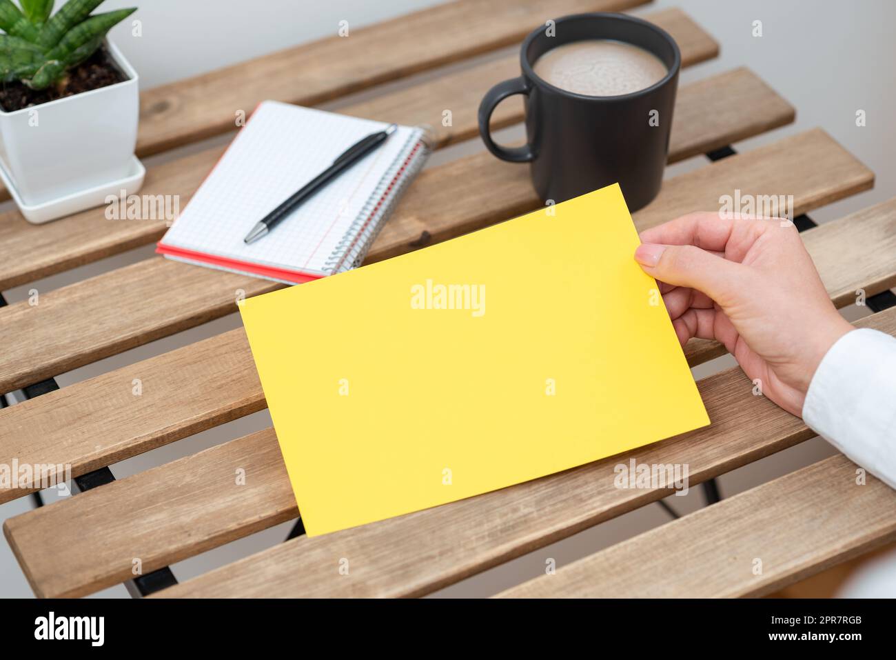 Businesswoman Holding Important Messages On Table With Coffee, Notebook, Pen And Plant. Woman ...