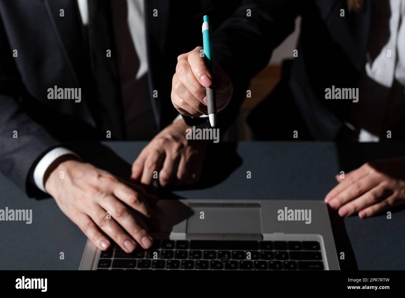 Man Typing On Lap Top And Woman Pointing With Pen On Important Message ...