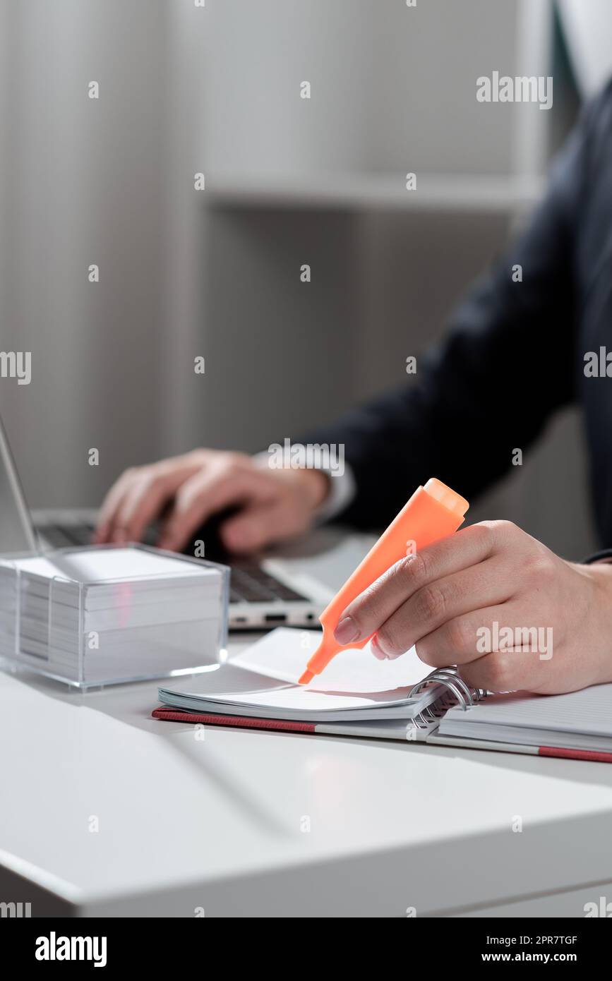 Businesswoman Writing In Notebook And Typing On Lap Top On Desk With ...