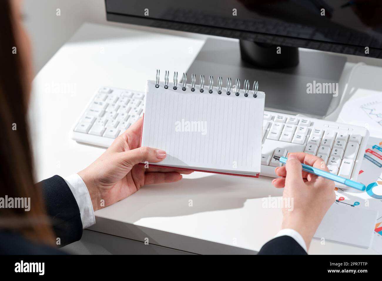 Businesswoman Holding Pen And Notebook With New Ideas Over Desk With ...