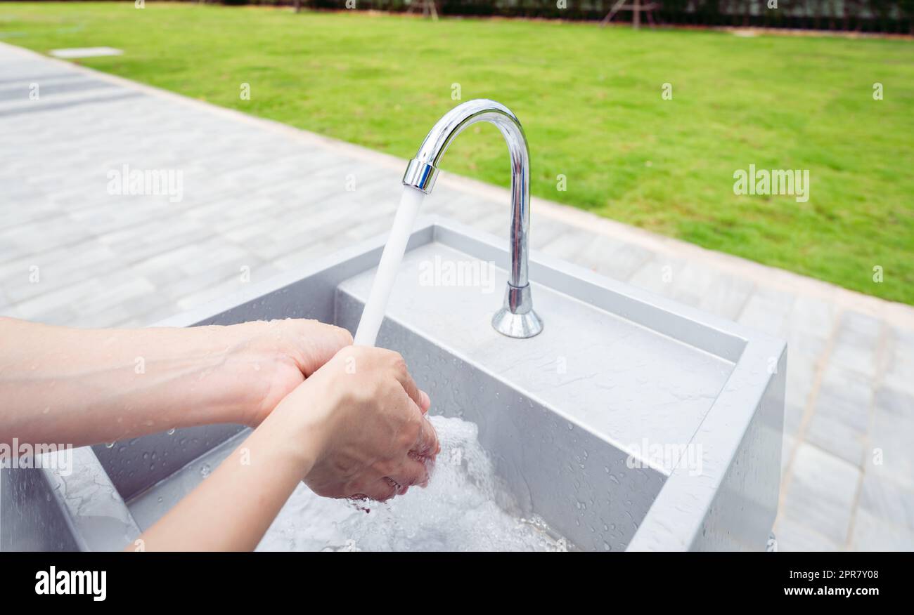 Woman washing hands with tap water under faucet at white sink. Washing ...