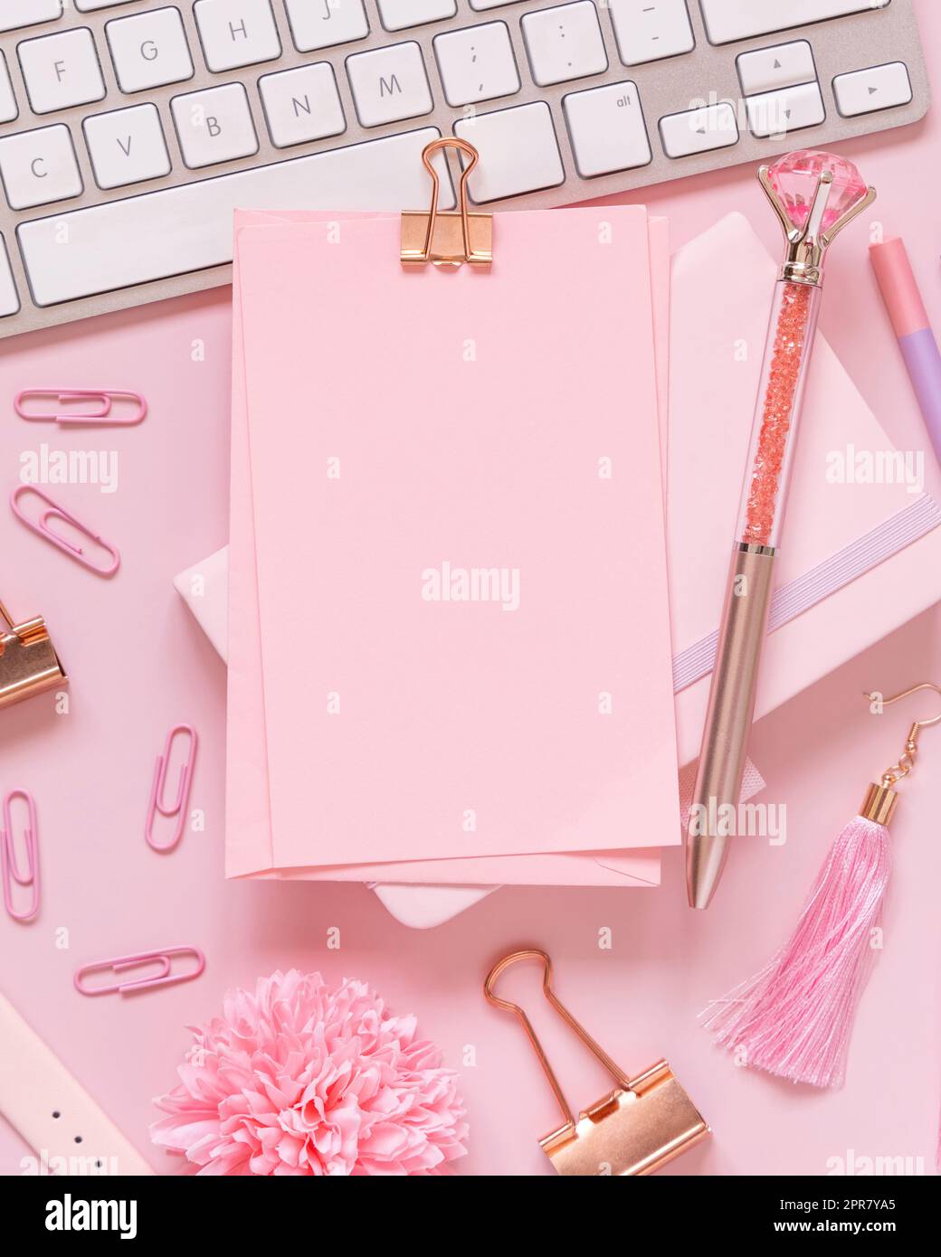 Paper with a clip, pink girly accessories and keyboard on pastel pink ...