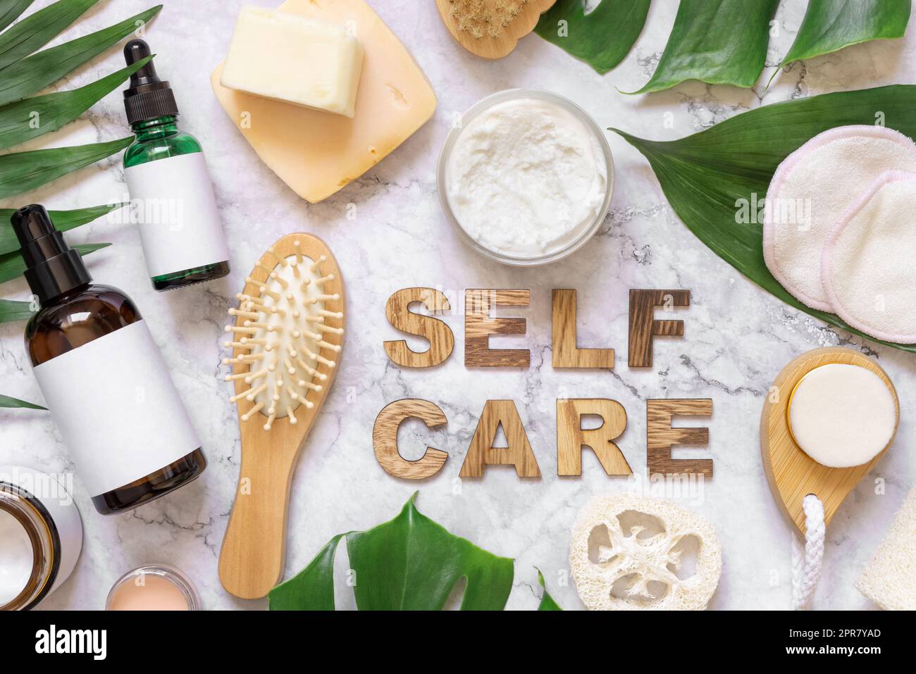 Self Care text near cosmetics, skincare accessories and monstera leaves ...