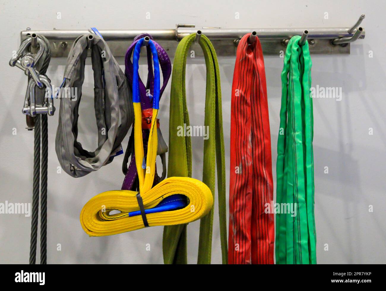 Several color-coded lifting straps, called slips, hang from a station ...