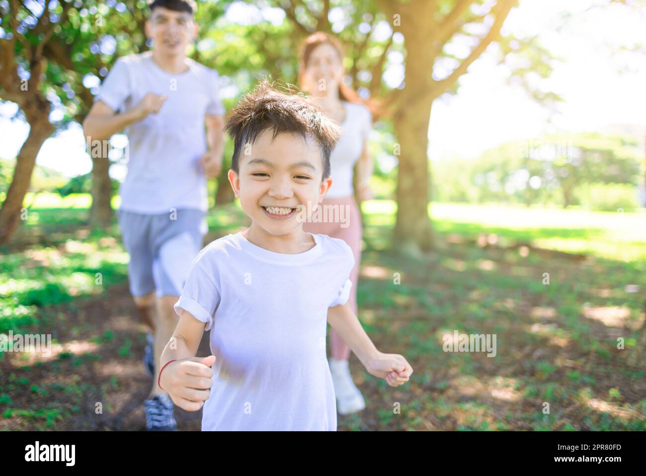 Happy kid Jogging with parents in the city park Stock Photo - Alamy