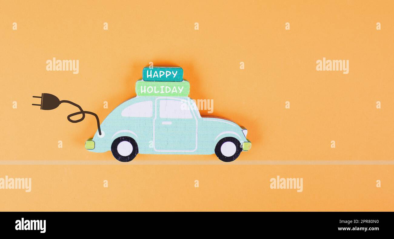 Small blue electric car with a cable for recharging, vacation trip with ...