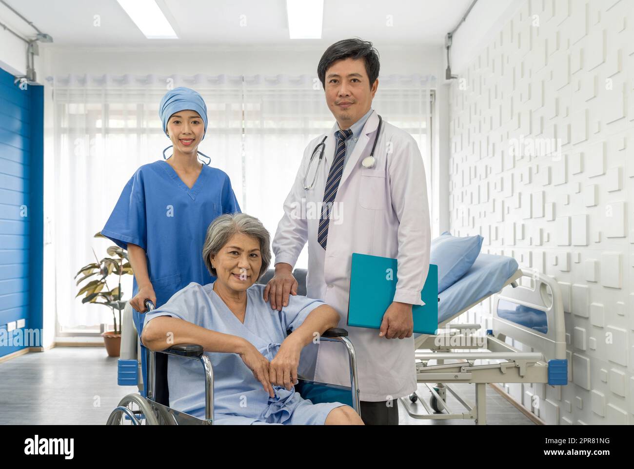 Senior female patient and doctor. Young nurse push a wheelchair of the ...