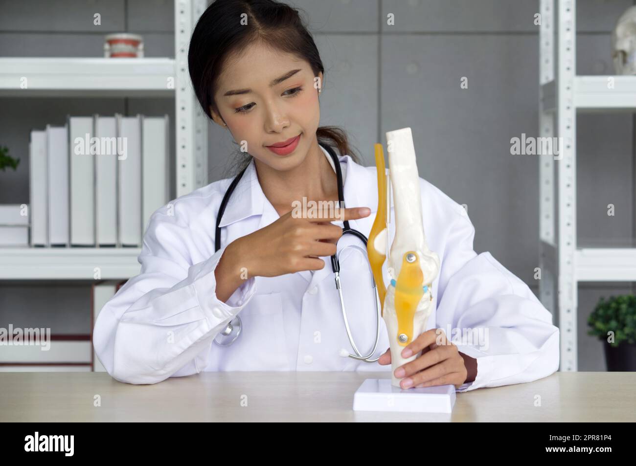 Young asian doctor in white gown and stethoscope pointing at anterior ...