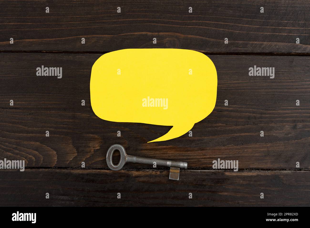 Speech Bubble Made Of Color Paper With Key Lying Over Wooden Background ...