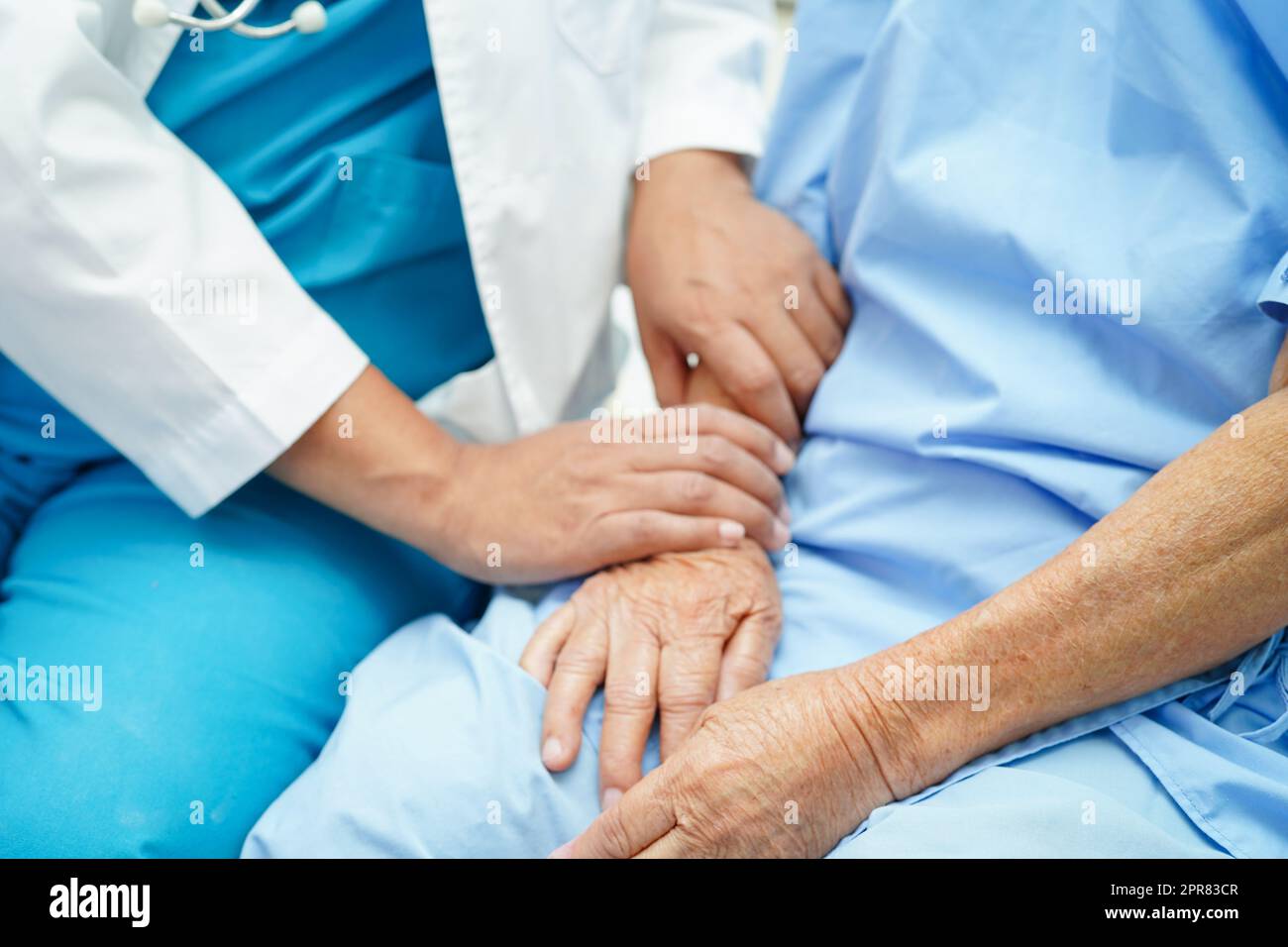Doctor taking care, help and encourage Asian elder senior woman patient ...
