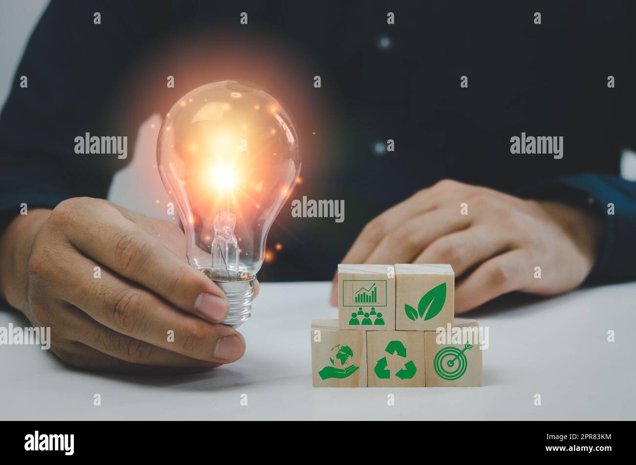 Hand man holding bulb light and wood cube green eco environmental and ...