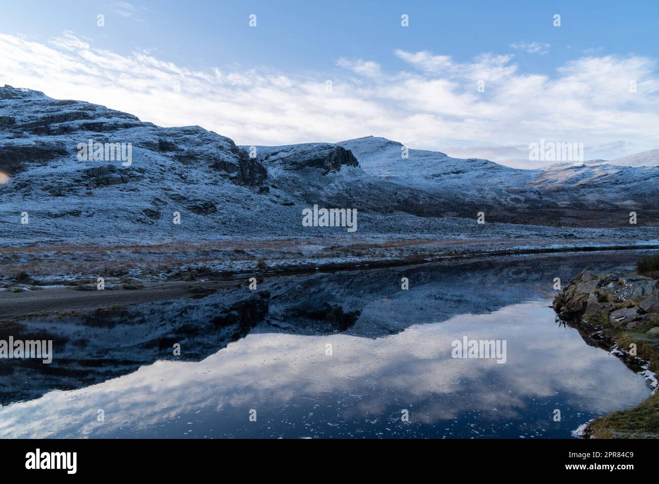 A scenic winter landscape featuring an expansive lake surrounded by ...