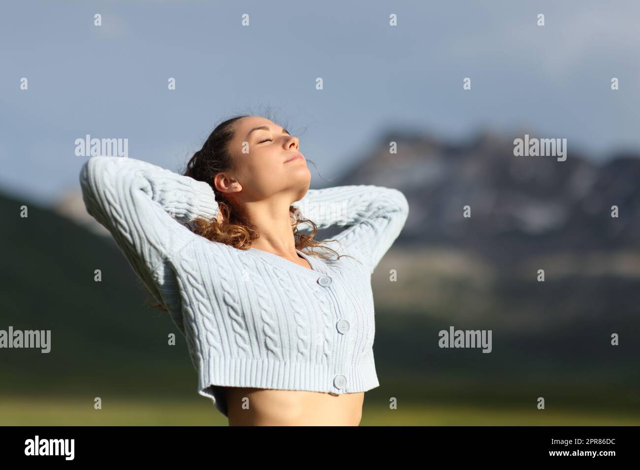 Relaxed female breathing fresh air in the mountain Stock Photo - Alamy