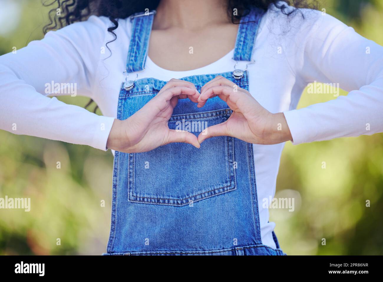 Respond with love. an unrecognizable woman forming a heart shape while ...