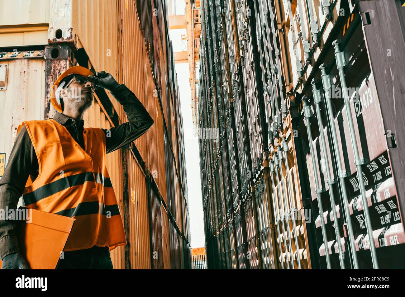 Man at work among containers in a commercial port Stock Photo - Alamy