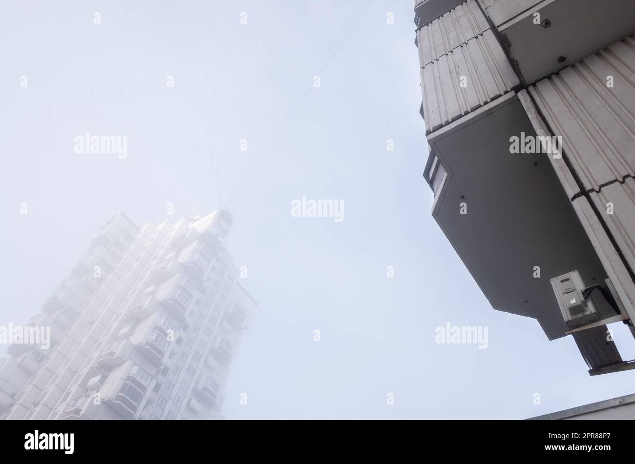 Tall residential buildings in the form of a tower, immersed in a misty ...