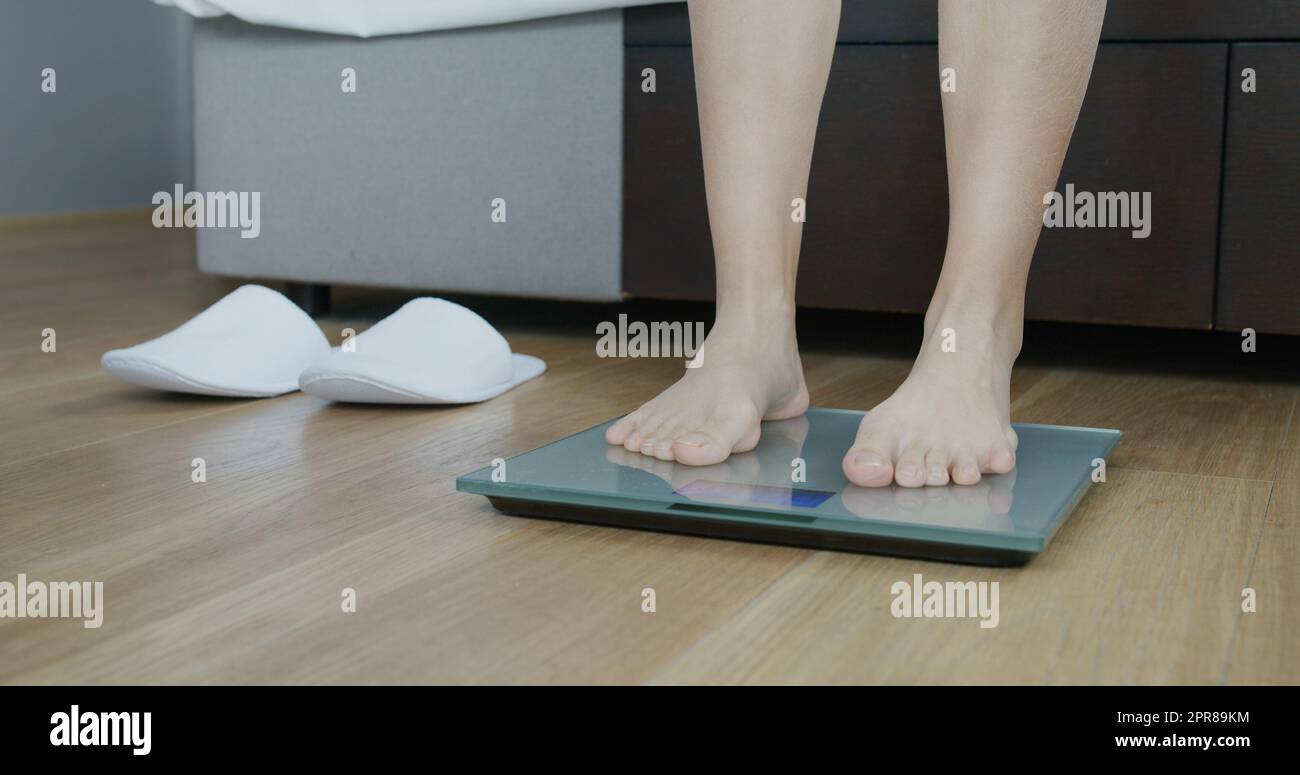 Woman on scales measure weight Stock Photo - Alamy