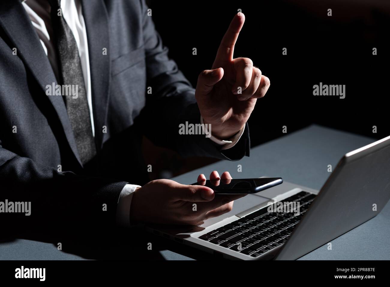 Businessman Holding Mobile Phone In Hand And Pointing With One Finger ...