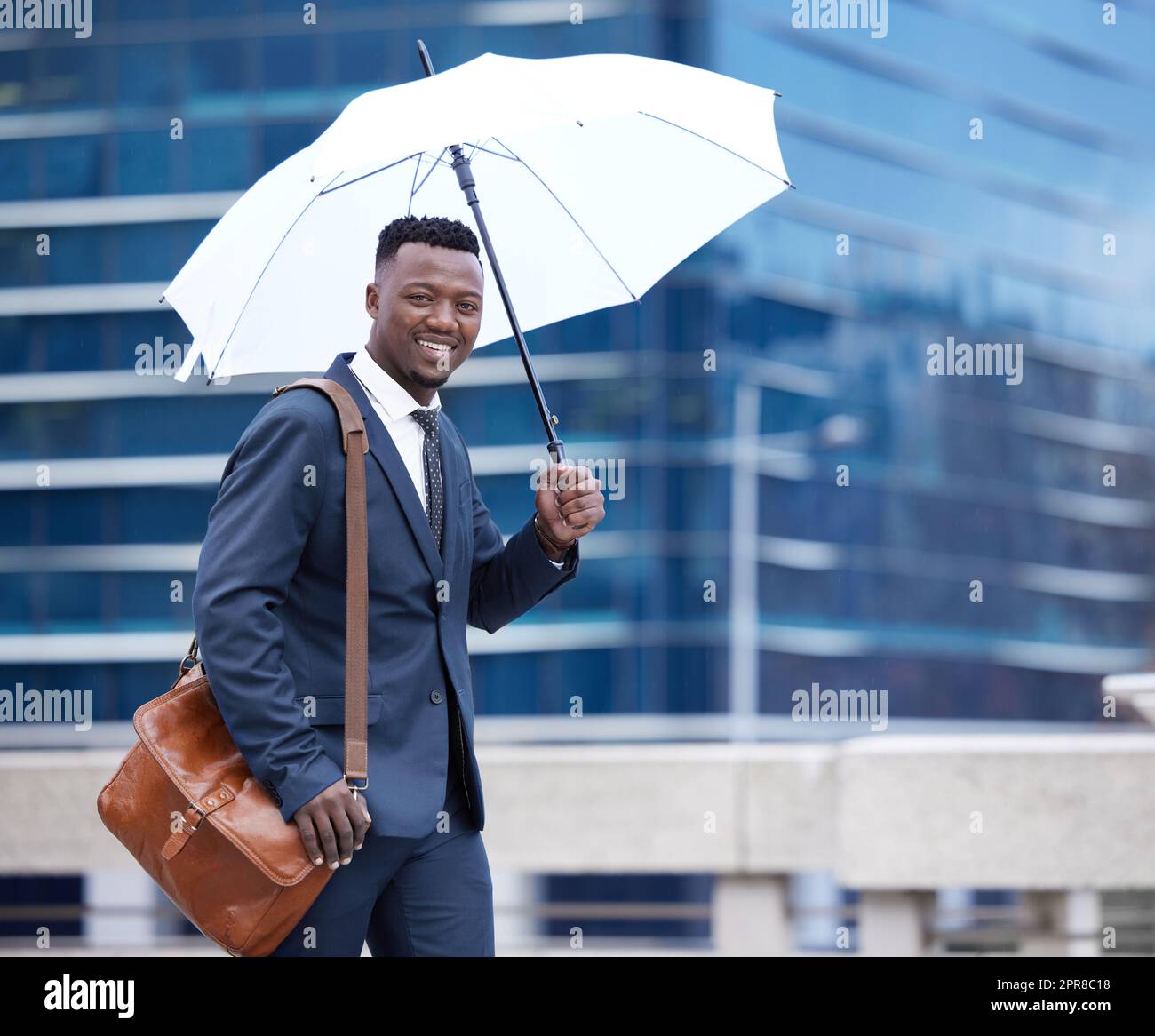 Im prepared for any weather. a young businessman holding an umbrella in ...