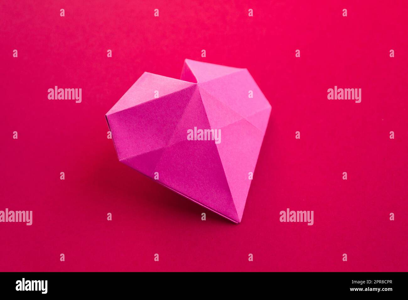 Pink paper heart origami isolated on a red background Stock Photo - Alamy