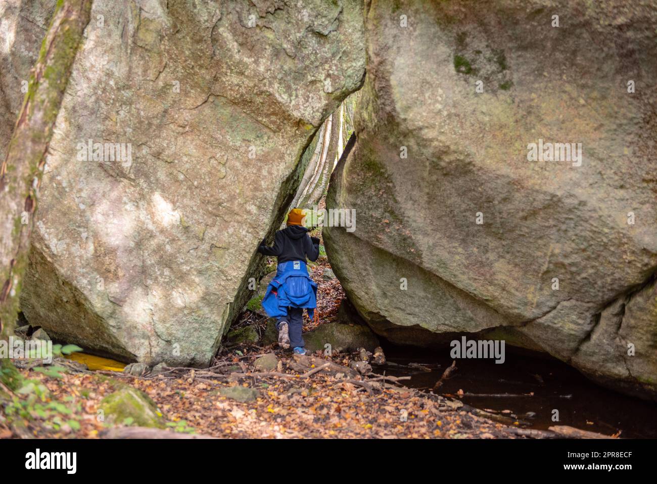 A person walking between two large boulders Stock Photo - Alamy